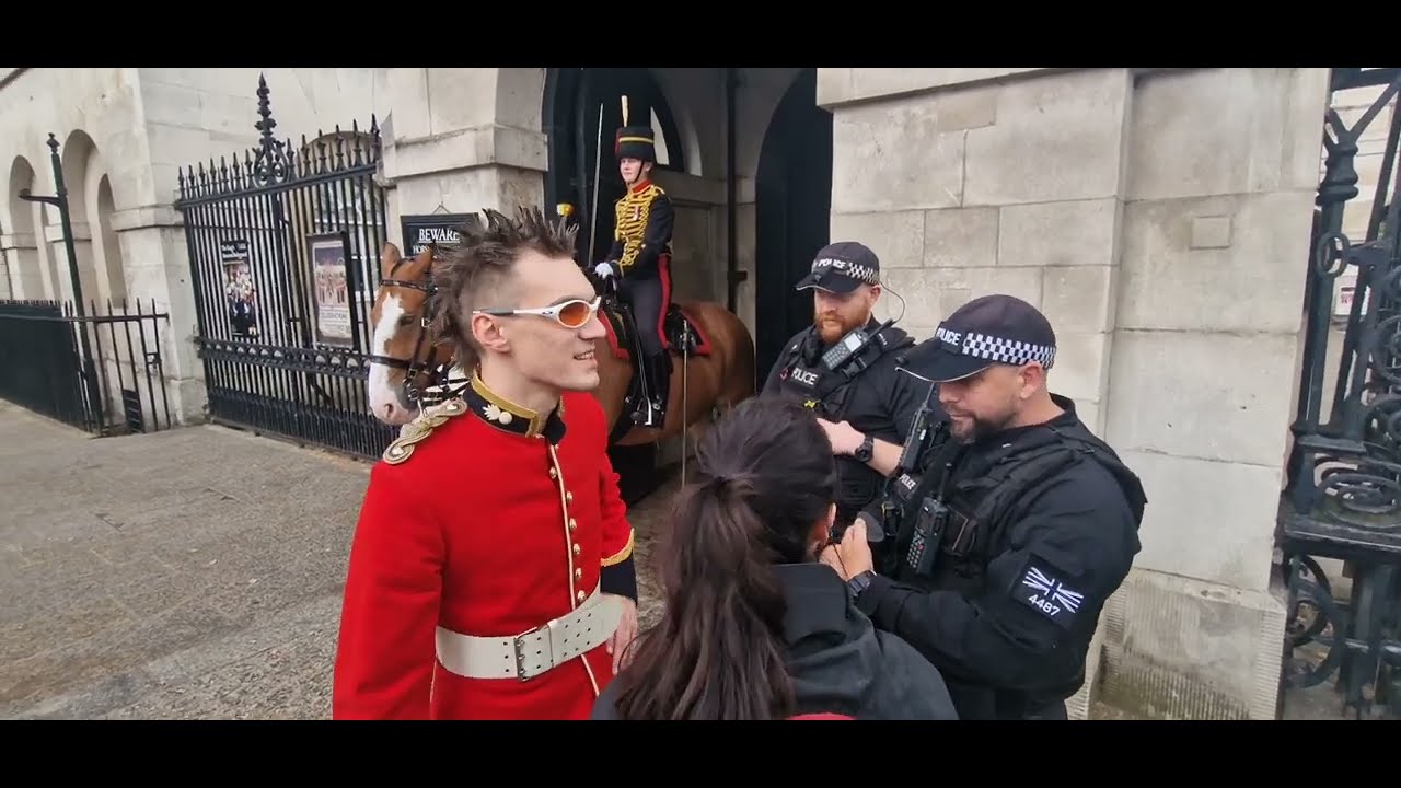Police confront man dressed as a kings guard making a rap video